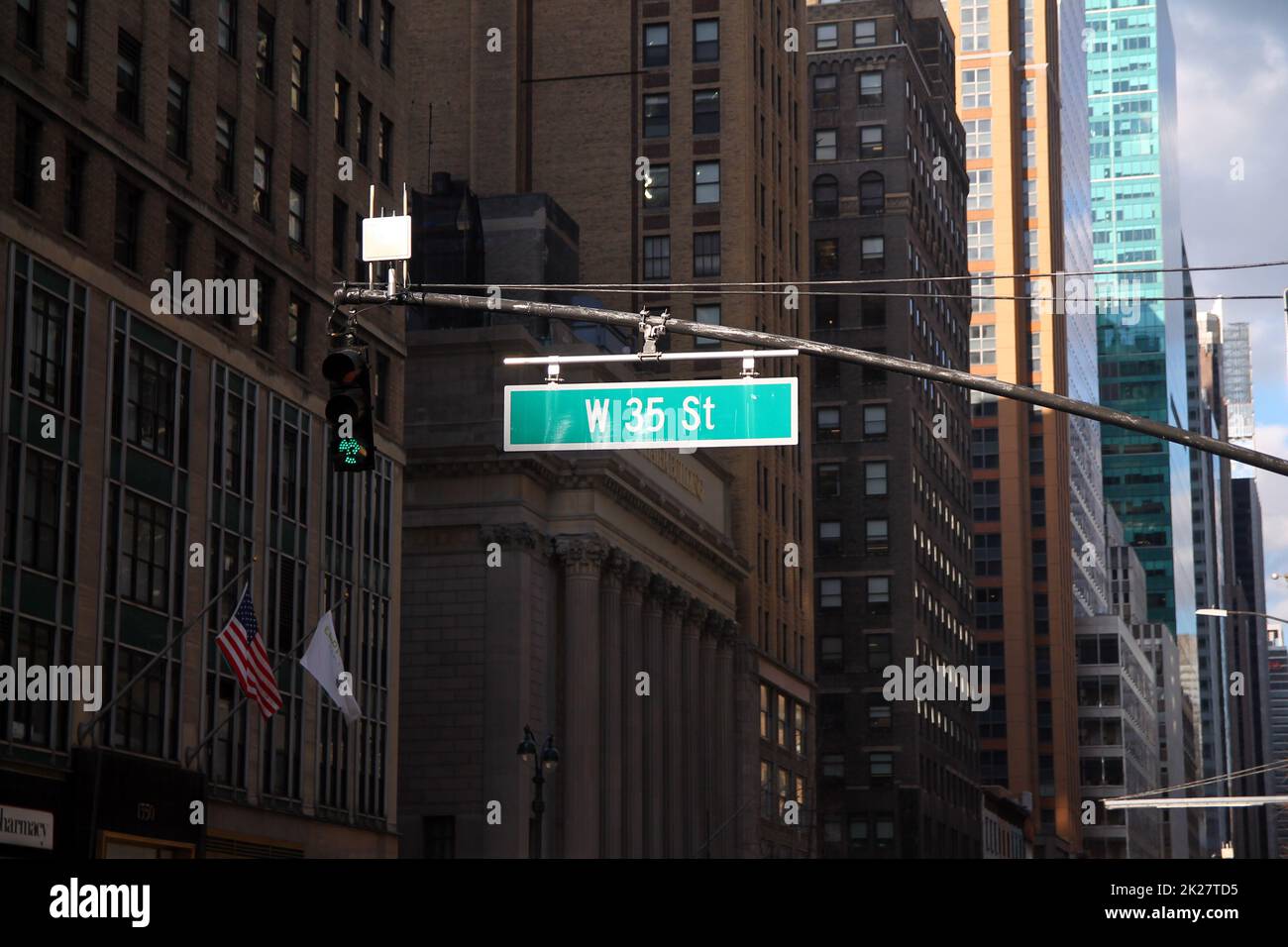 Green big West 35th Street sign hanging on a arch pole in the streets ...