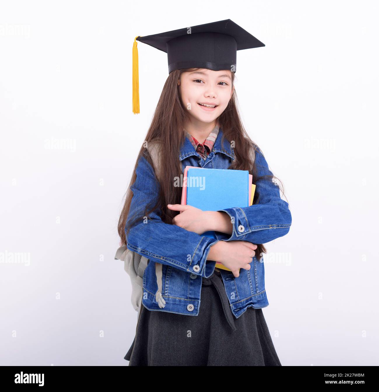 Smiling girl student holding with and standing on white background ...