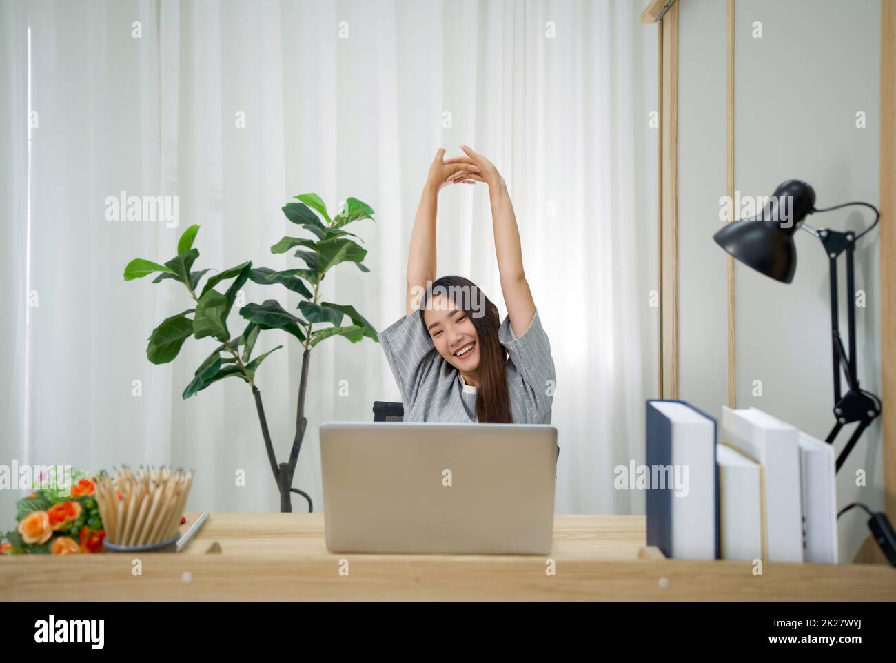 Young woman are relaxed and stretching her arms after finish home work ...