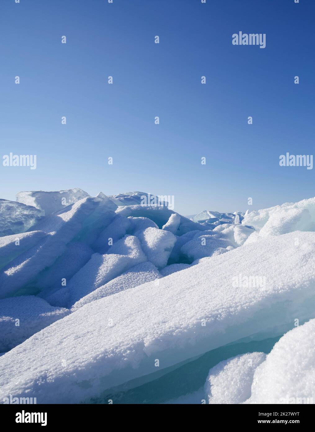 Closeup ice that covered with white snow. Water in the lake became ...