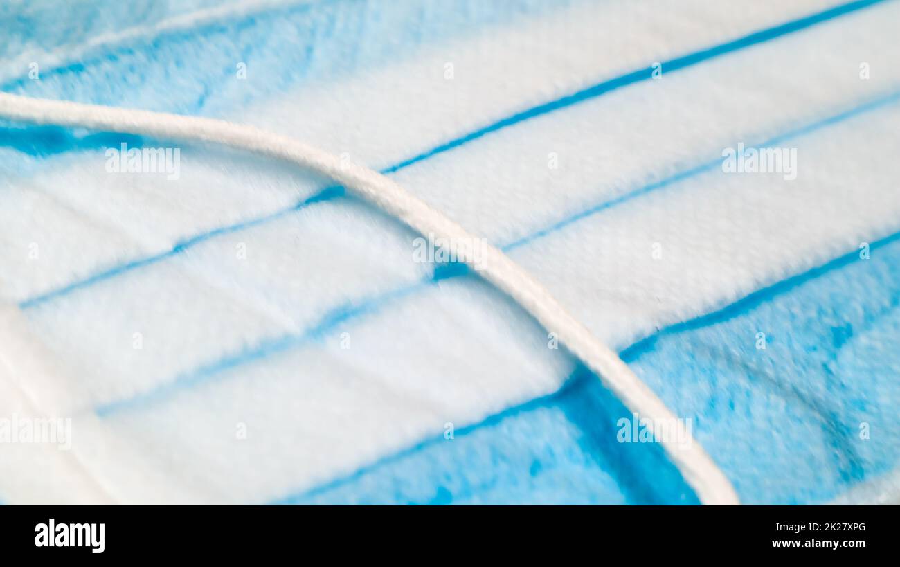 One 3-ply disposable surgical face mask close-up with rubber pads ...