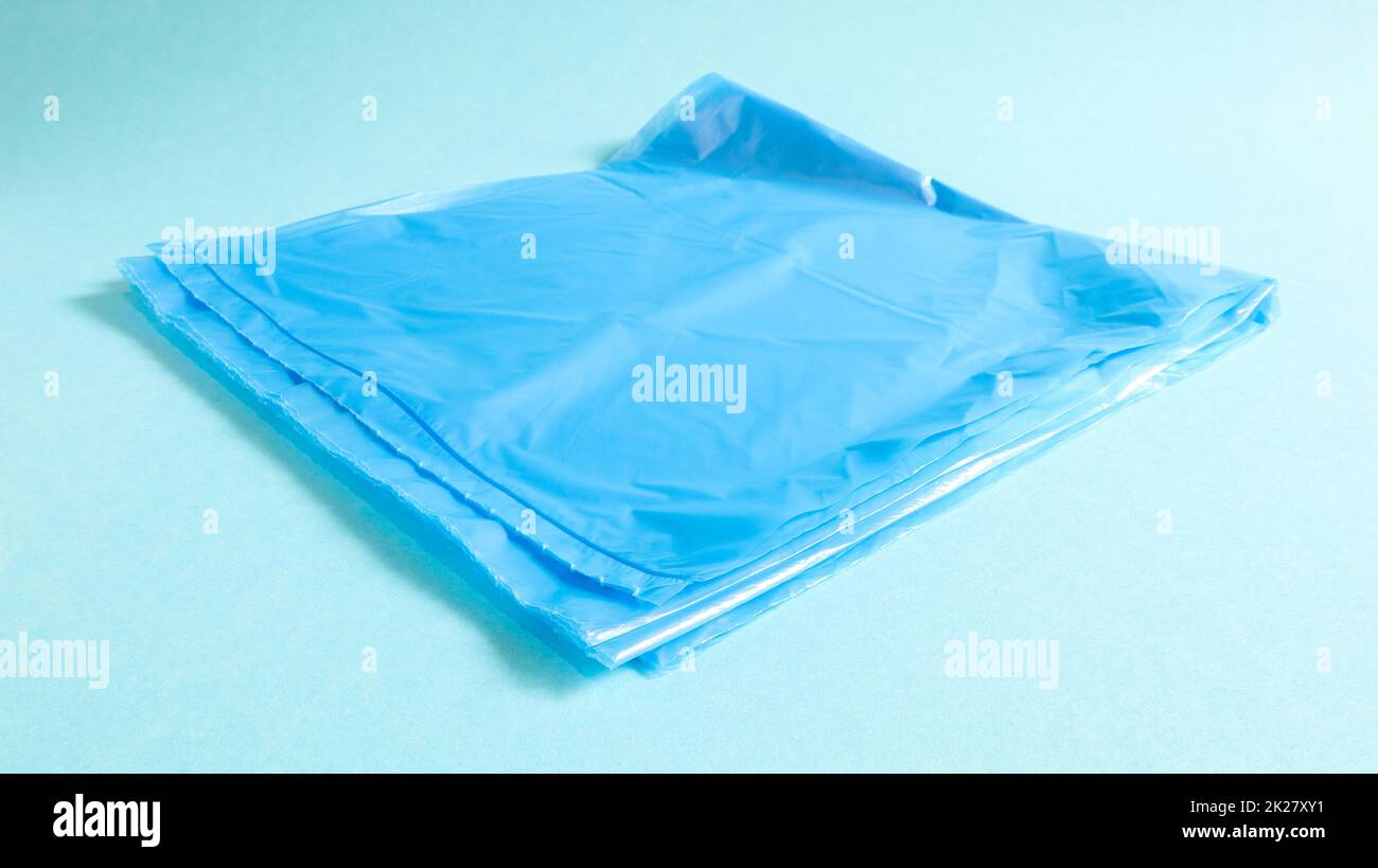 One torn plastic garbage bag in blue on a blue background. A bag that ...