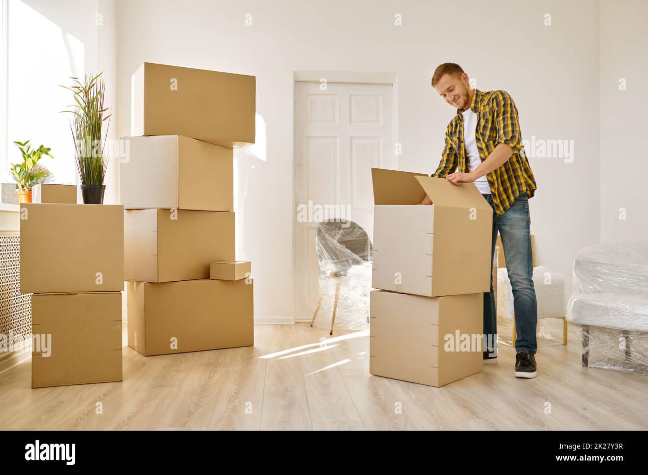 Man packing stuff among plenty of boxes Stock Photo - Alamy