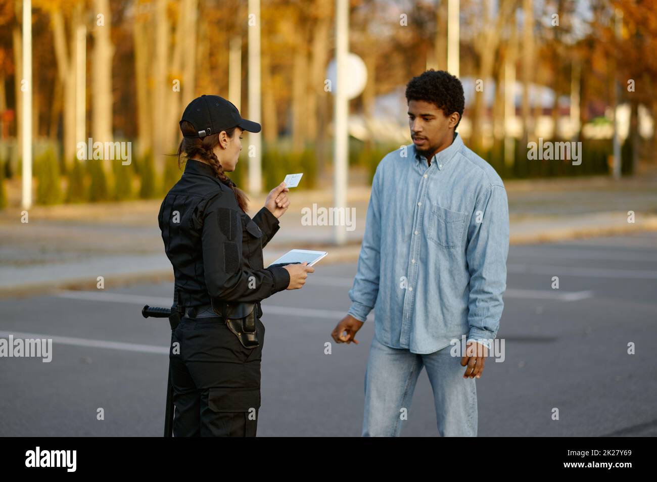 Female cop checking male passerby ID document Stock Photo - Alamy