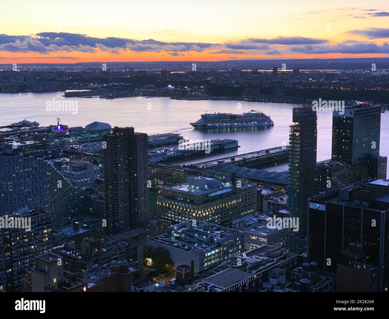 A dramatic shot of a cruise leaving the harbour during a violet sunset ...
