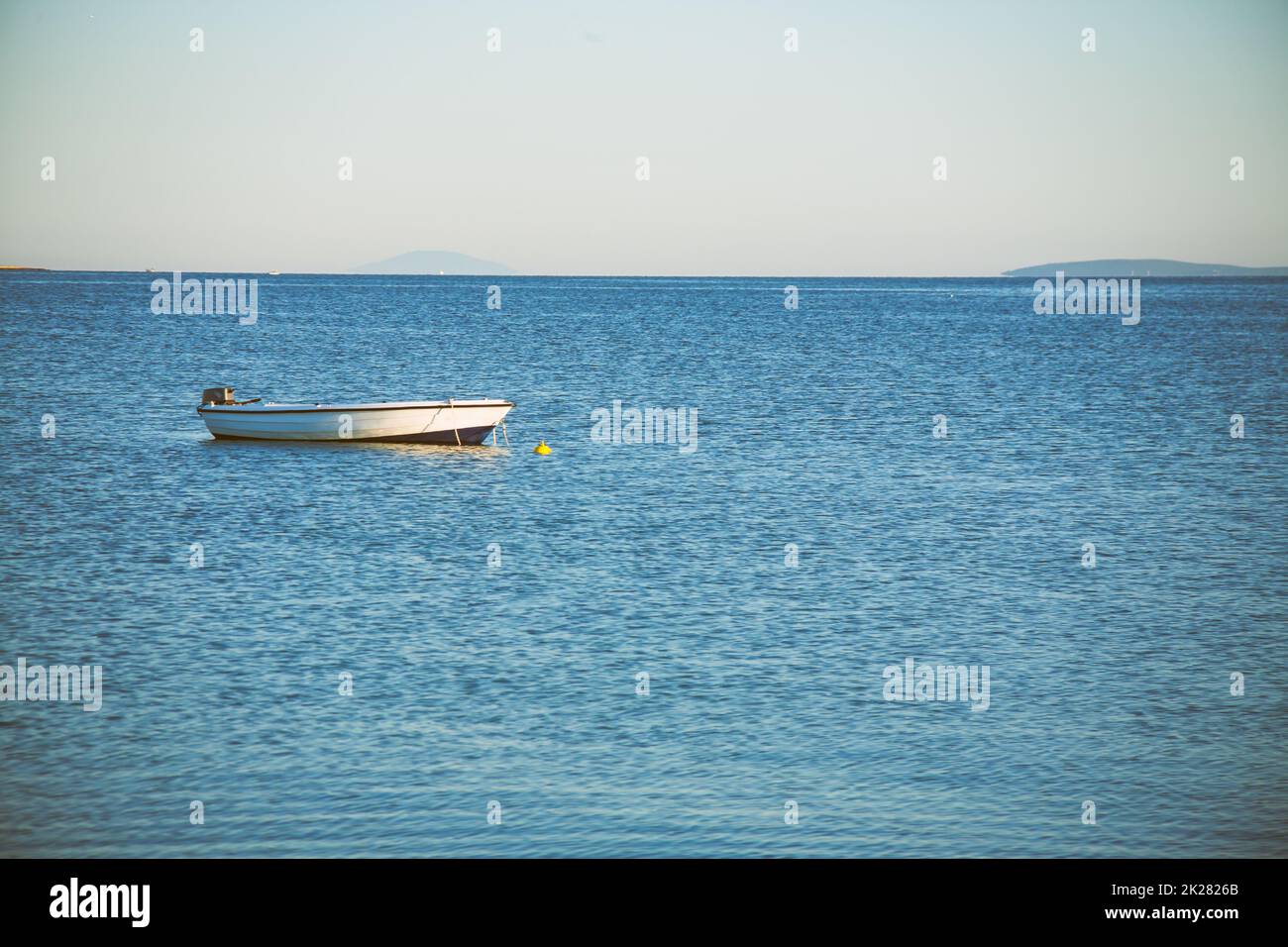Small fishing boat moored on a sea Stock Photo - Alamy