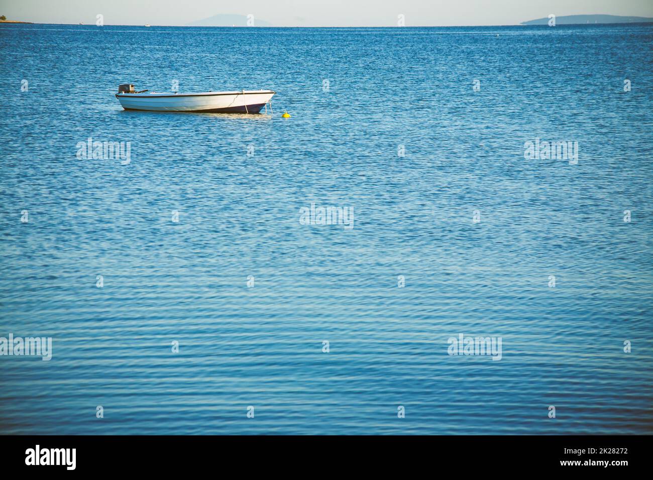 Small fishing boat moored on a sea Stock Photo - Alamy