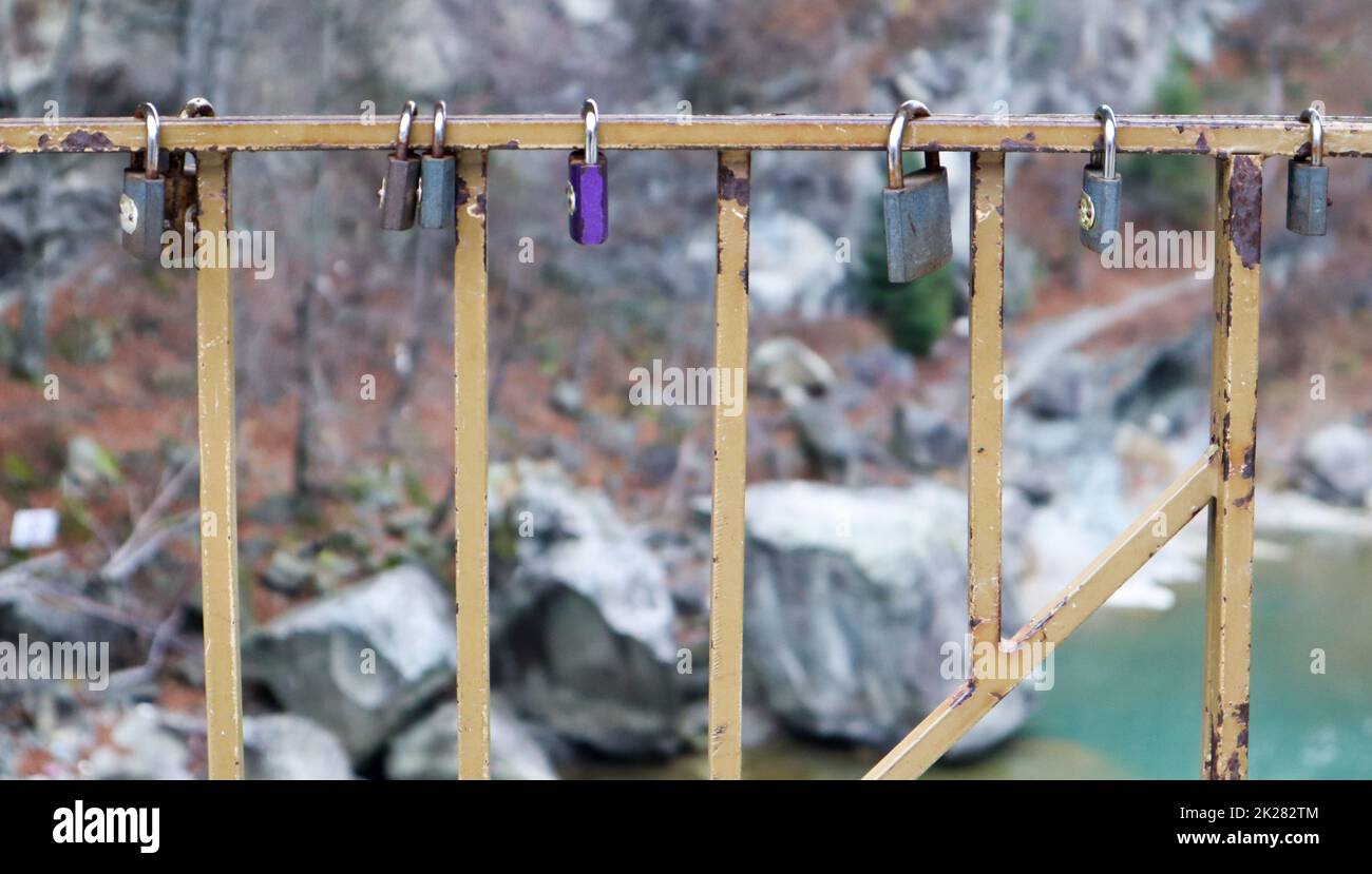 Many different locks hanging on the fence. The closed lock on the ...