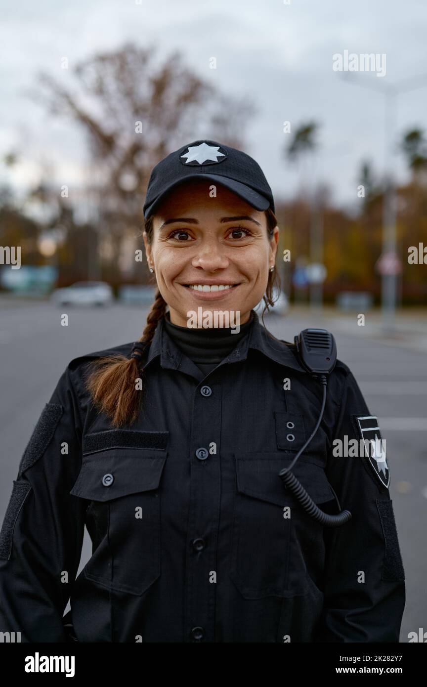 Portrait of smiling police woman on street Stock Photo - Alamy