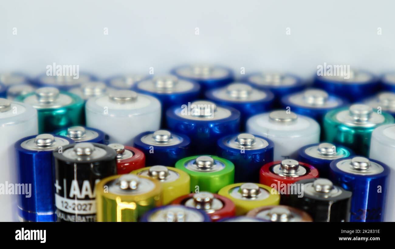 Lots of AA and AAA alkaline batteries on a white background. Ecological ...