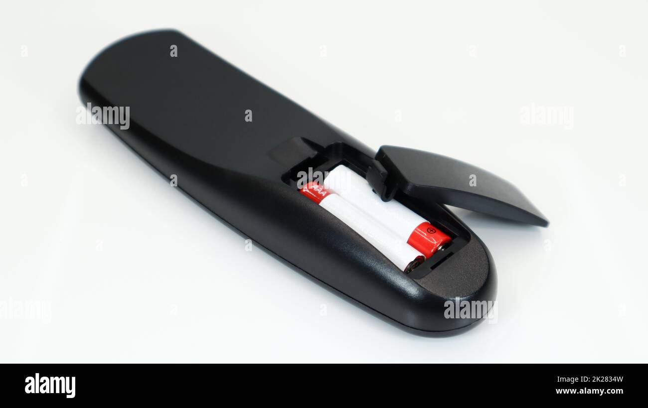 Black TV remote control with AAA alkaline batteries in red and white on ...