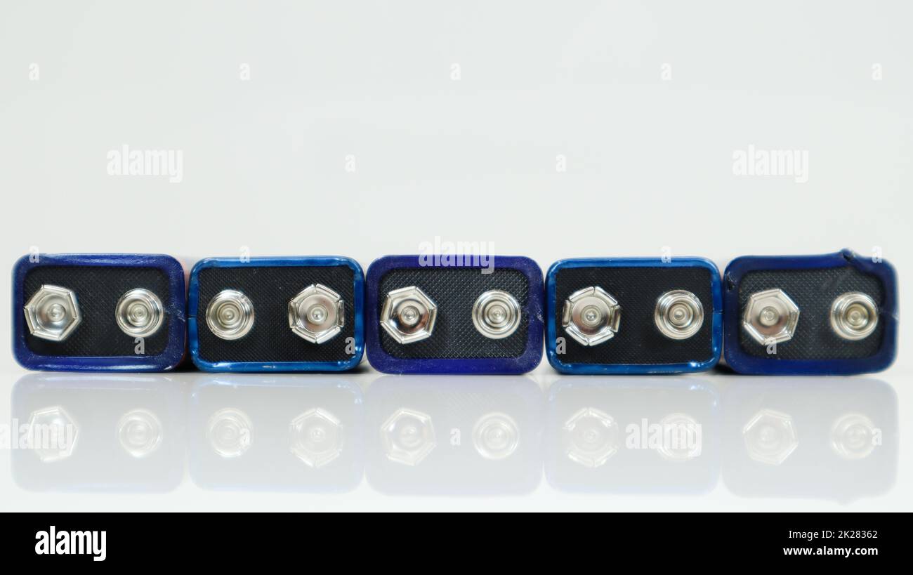 Five blue used PP3 batteries lined up on a white background with ...