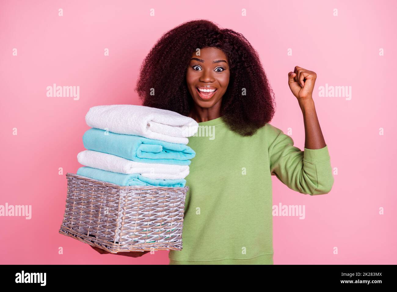 Photo of delighted excited person hold pile stack towels raise fists ...