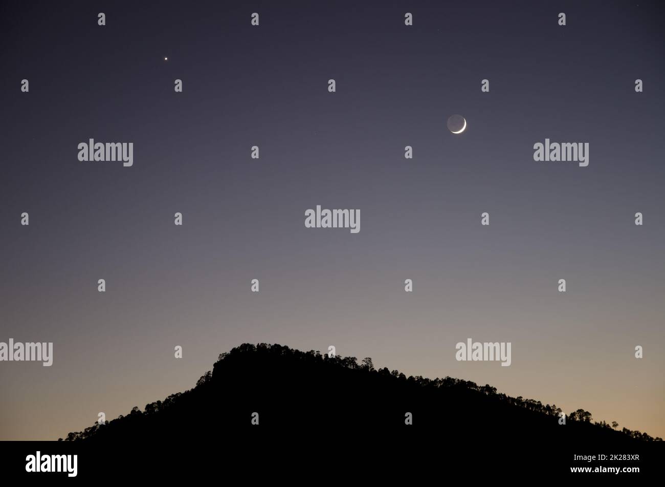 Polar star and waxing crescent moon over Alsandara Mountain Stock Photo ...