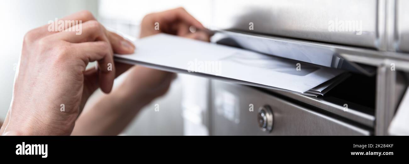 Human's Hand Inserting Letters In Mailbox Stock Photo - Alamy