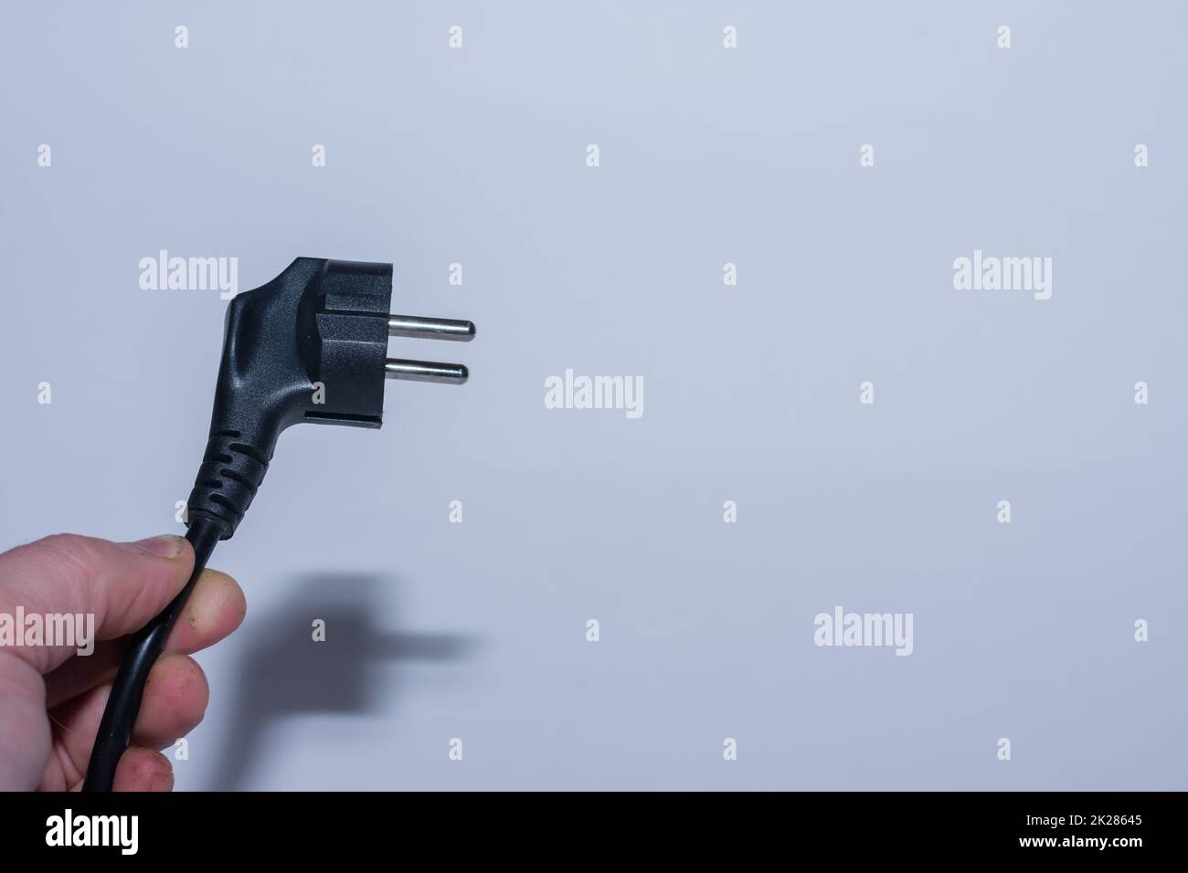 plug held oblique in one hand save electricity left view with gray ...