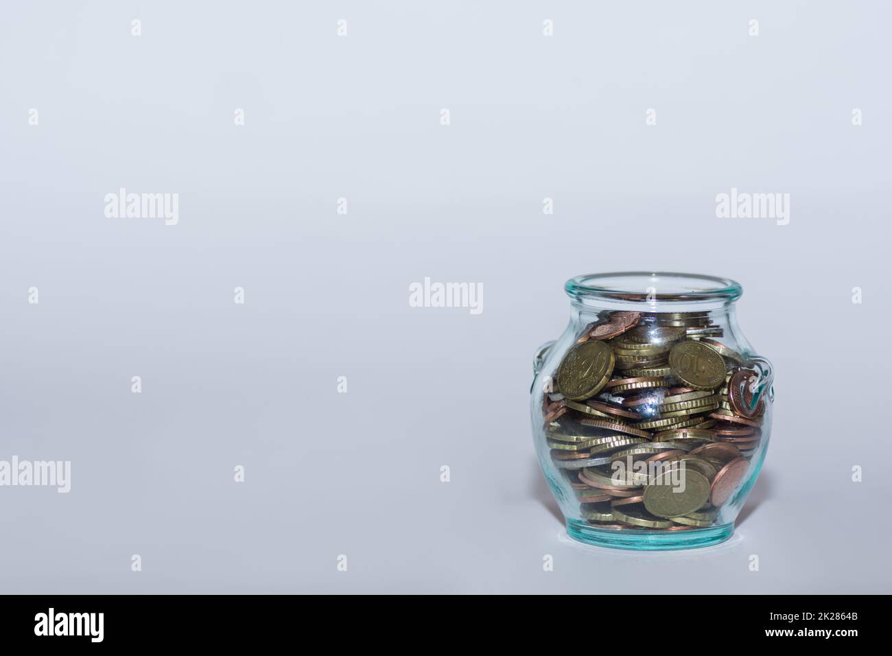 saved money in a jar with many different euro coins for financial ...