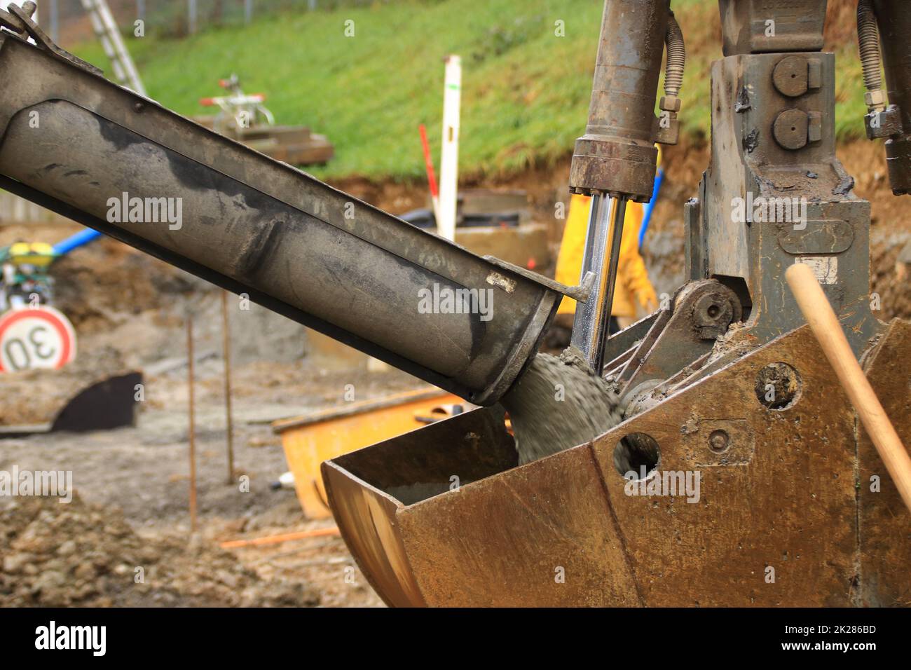 Liquid concrete is filled into the grab by an excavator Stock Photo - Alamy