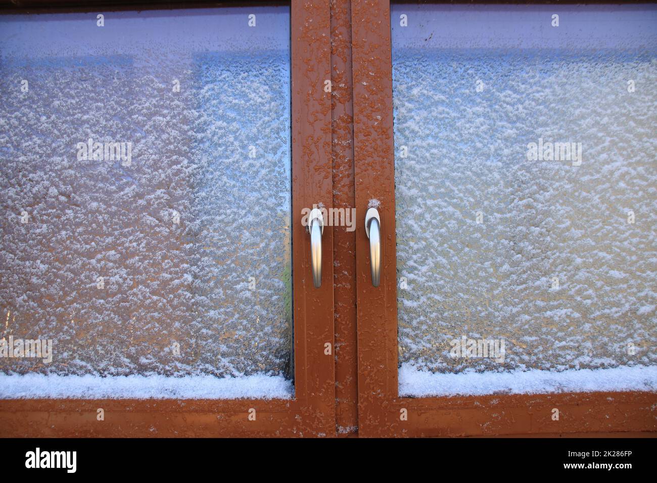 Window is covered with snow from the inside through a hole in the roof ...
