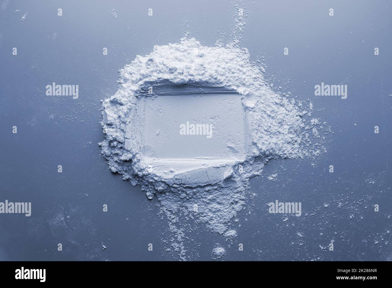 Powder with dent from card om blue background Stock Photo - Alamy
