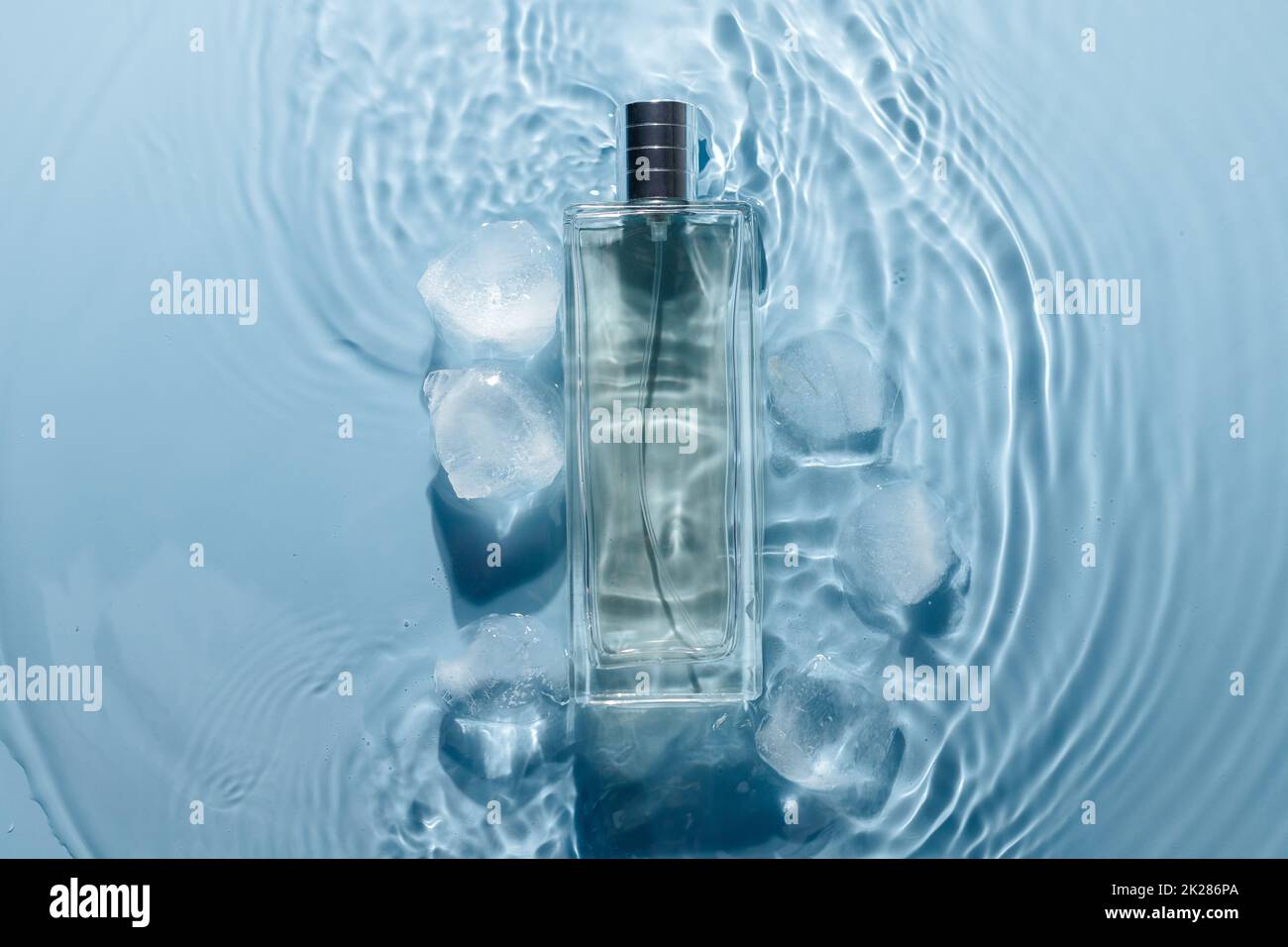 Perfume bottle on blue water wavy background with ice pieces. Fresh sea ...