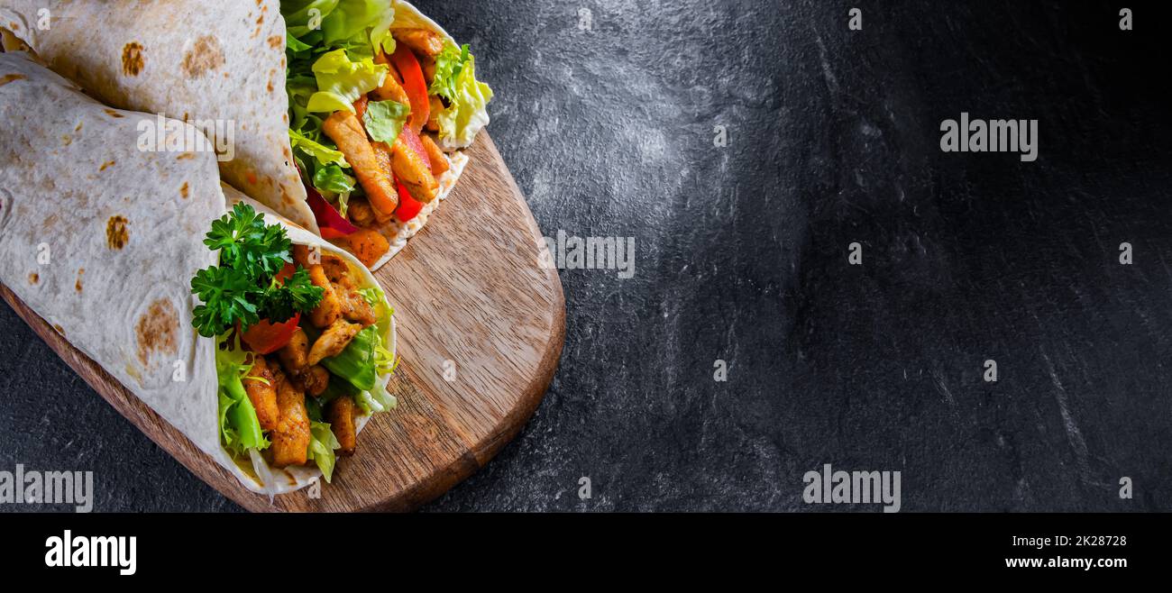 Tortilla with chicken and fresh vegetables on a cutting board Stock ...