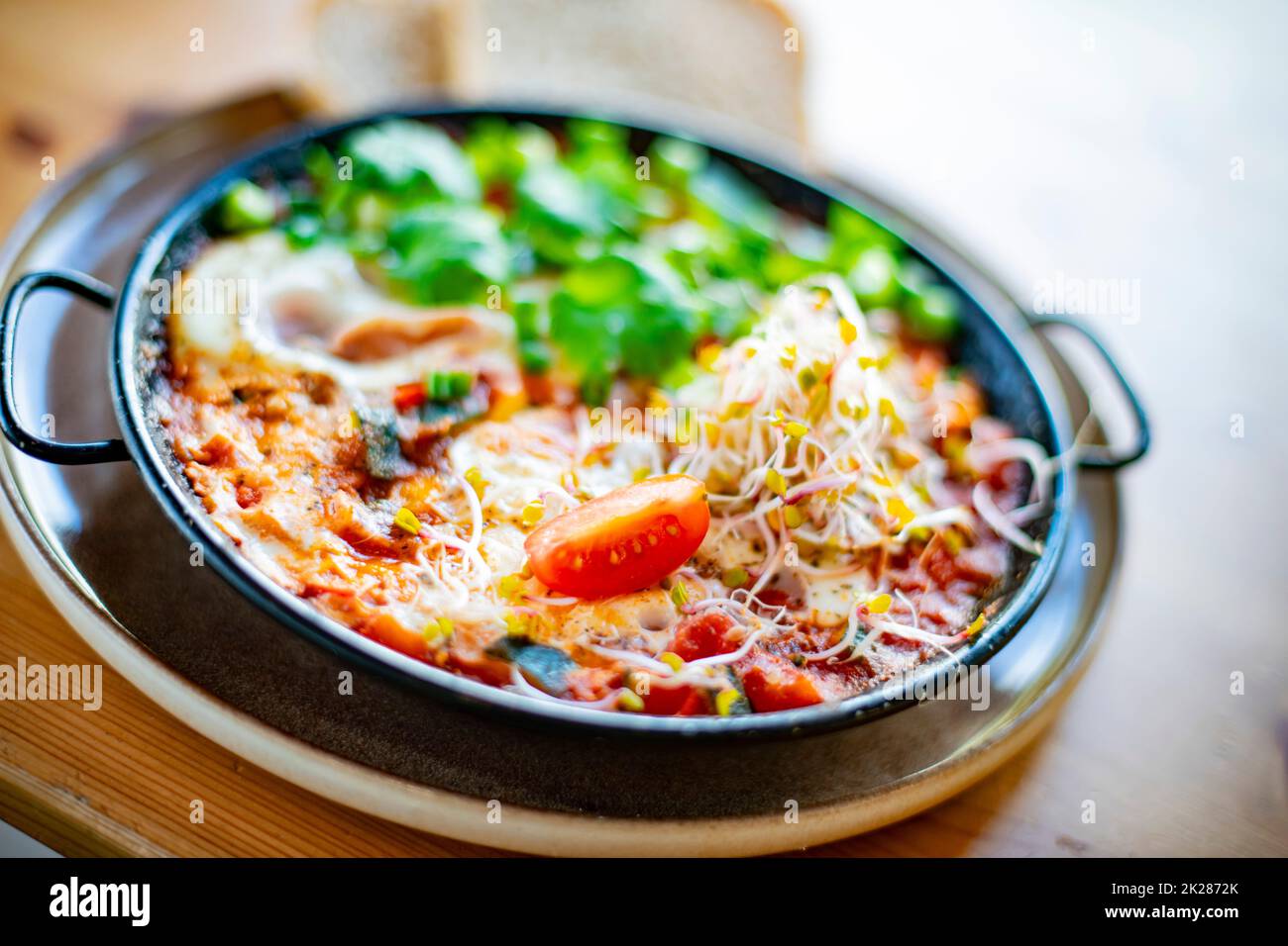 Egg shakshouka dish on a restaurant table Stock Photo - Alamy