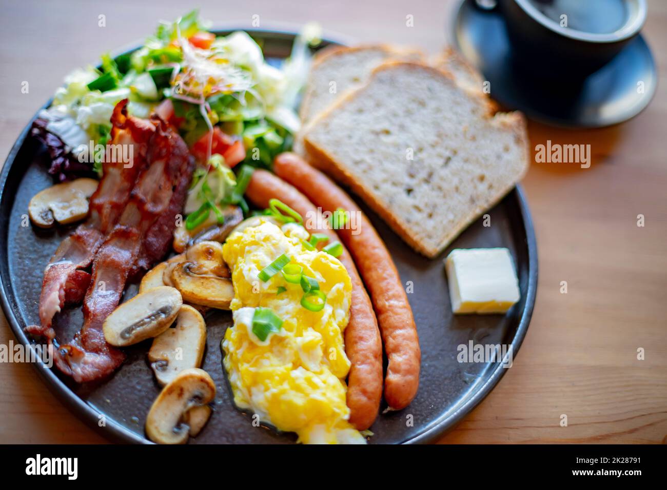 Breakfast with scrambled eggs, bacon, sausages and toast Stock Photo - Alamy