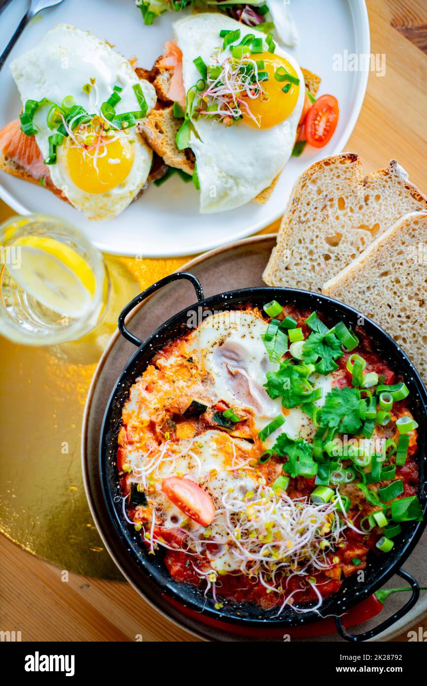 Egg shakshouka dish on a restaurant table Stock Photo - Alamy