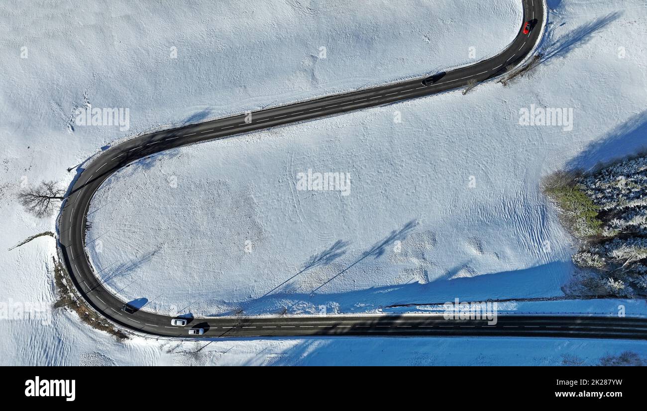 Aerial drone shot of snowy landscape with curvy road with cars Stock ...