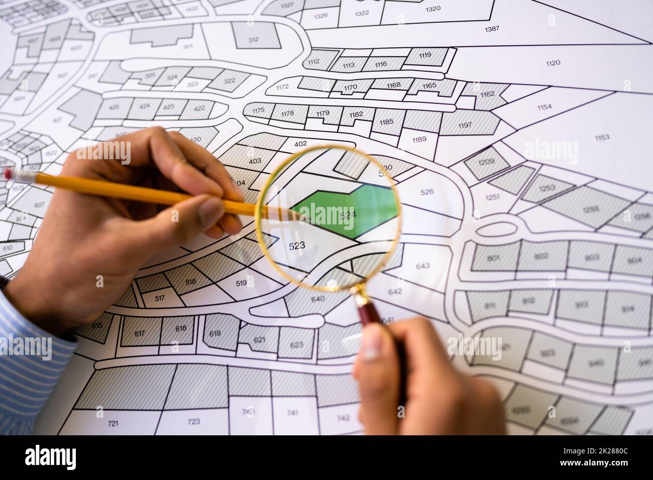 Close-up Of Human Hand Holding Pencil Over Paper Cadastre Stock Photo ...