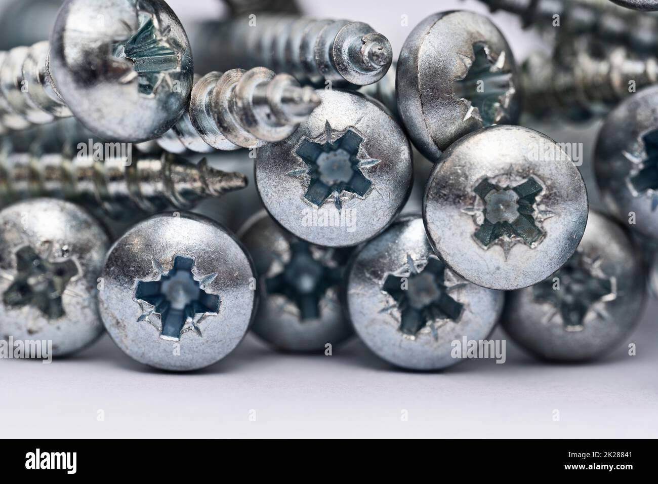 Close up of a pile of multipurpose metal screw heads Stock Photo - Alamy