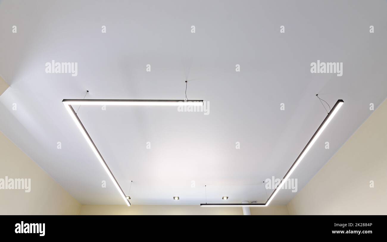 Modern white matte stretch ceiling with original fixtures Stock Photo ...