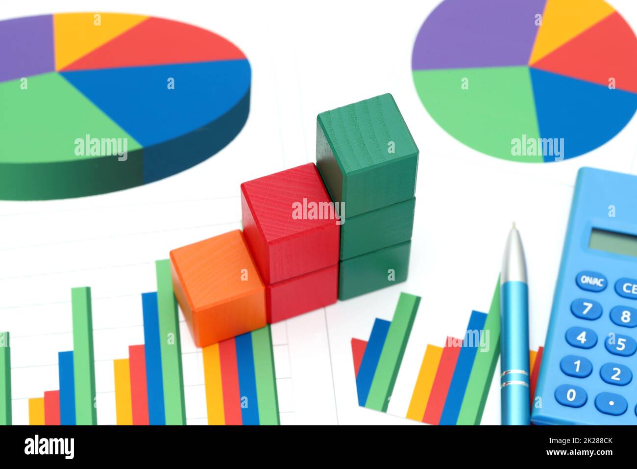 colorful wooden blocks with graph printed documents on white background ...