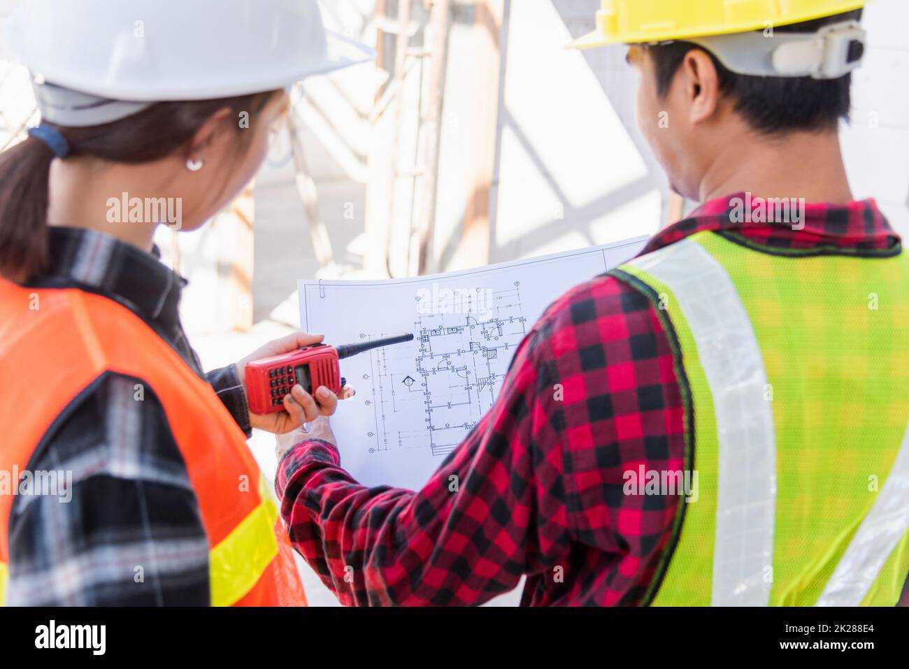 Architect and client discussing the plan with blueprint of the building ...