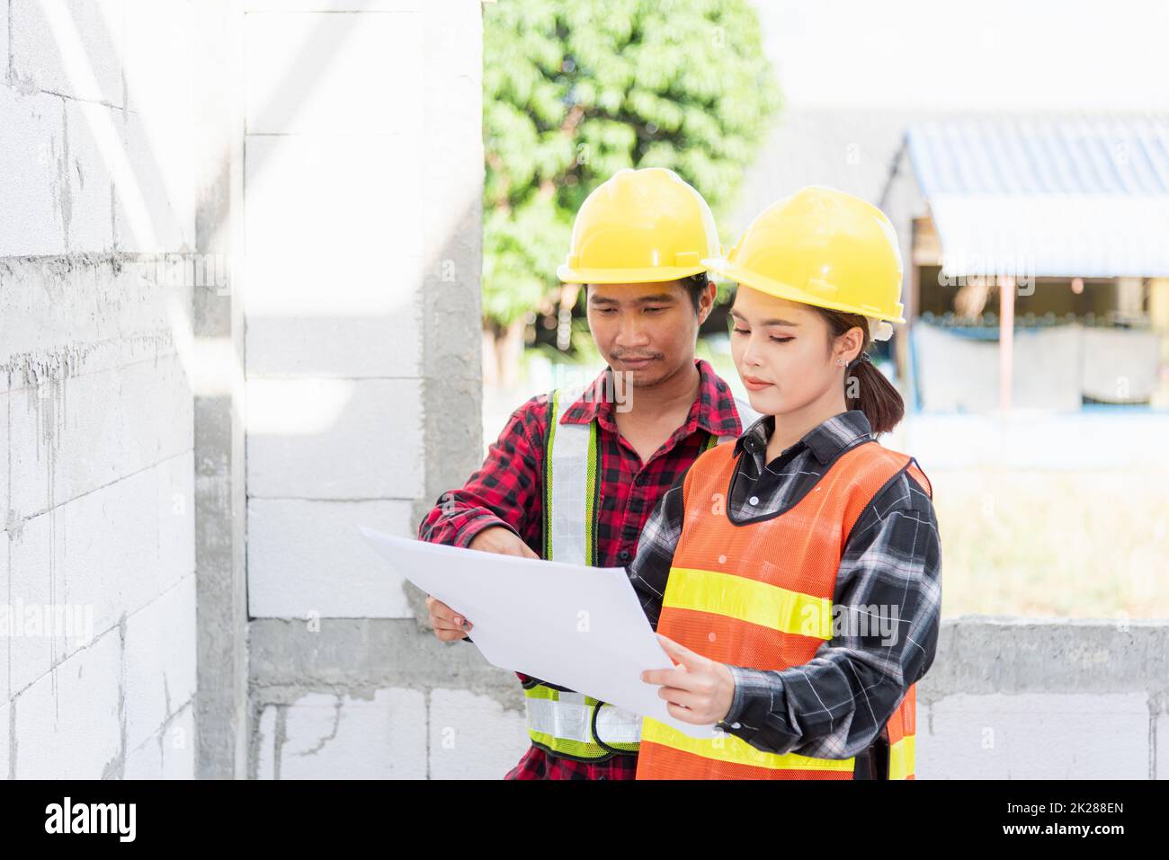 Architect and client discussing the plan with blueprint of the building ...