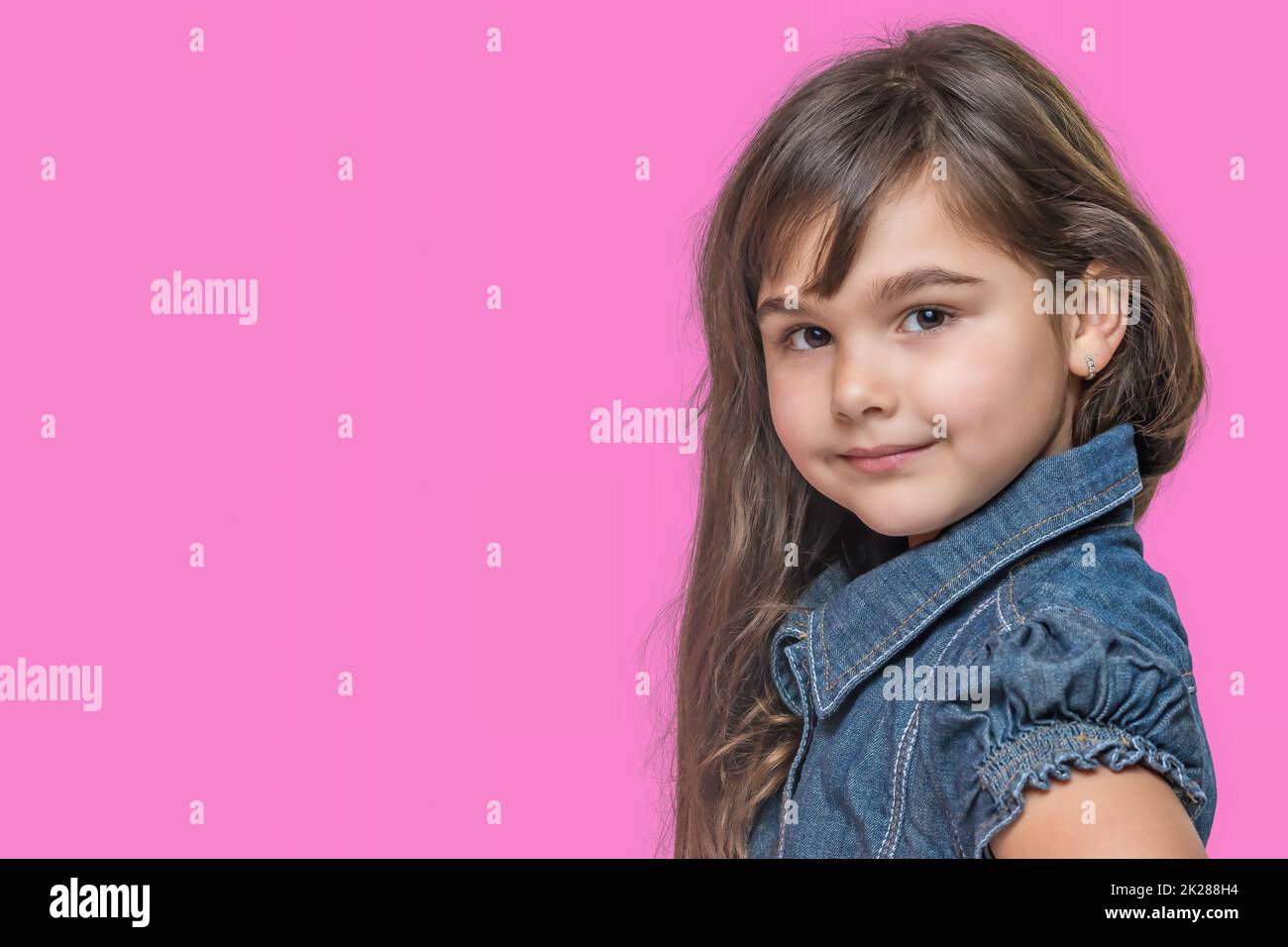Cute tanned little girl is posing on pink background Stock Photo - Alamy