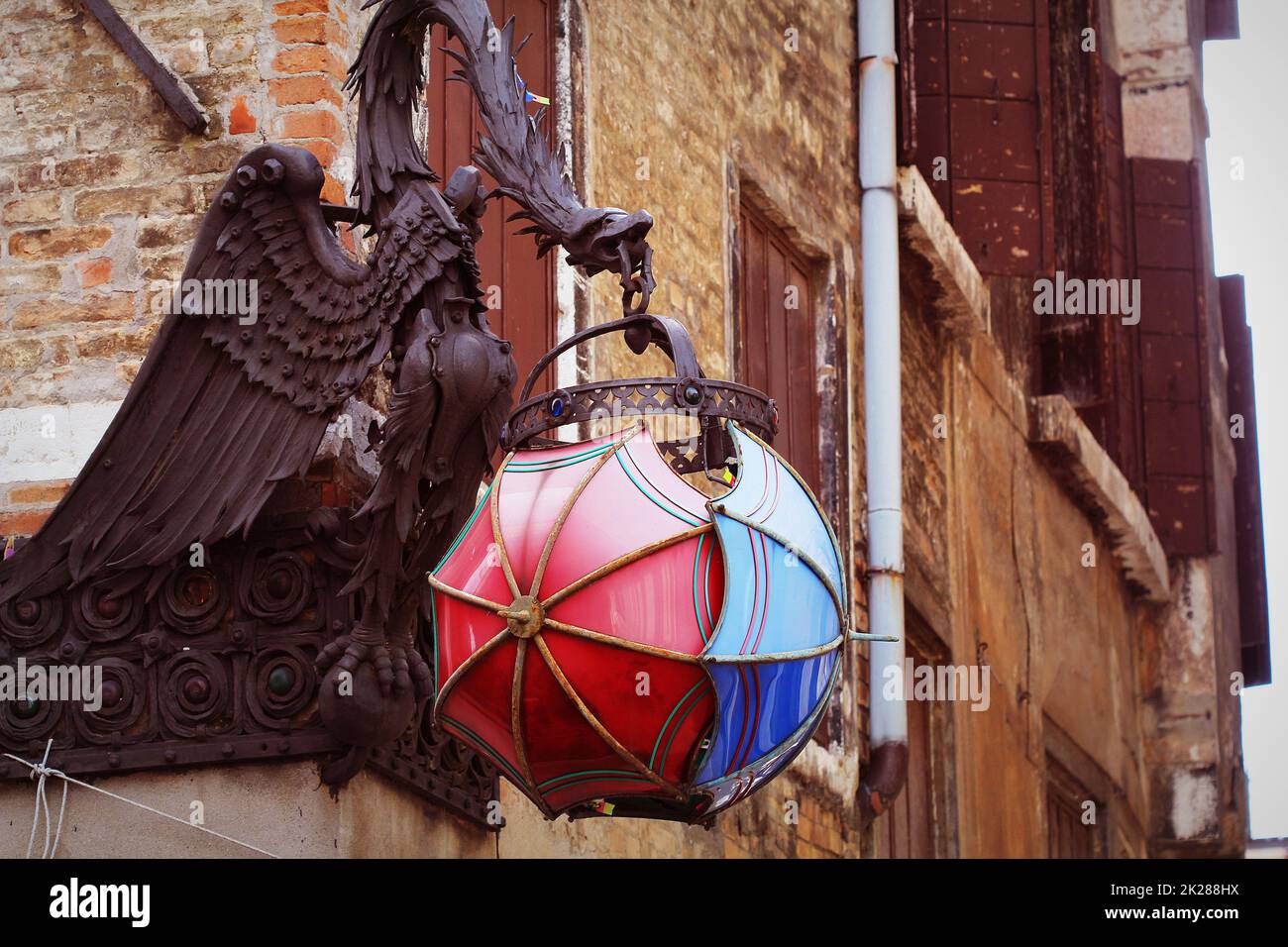 Ornate dragon and umbrella shop sign on a street corner in Venice Stock ...