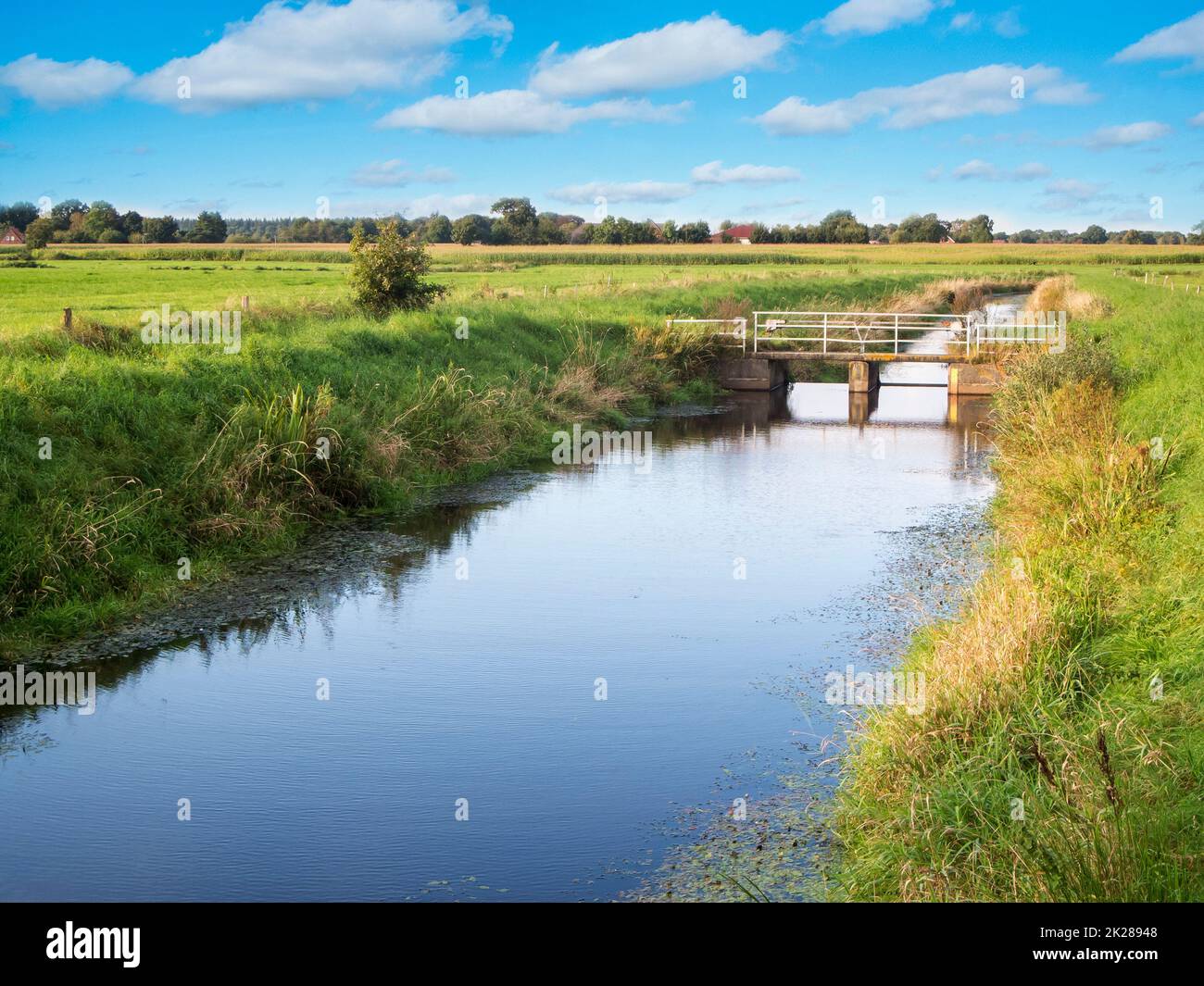 Drainage ditch with small pedestrian bridge Stock Photo - Alamy