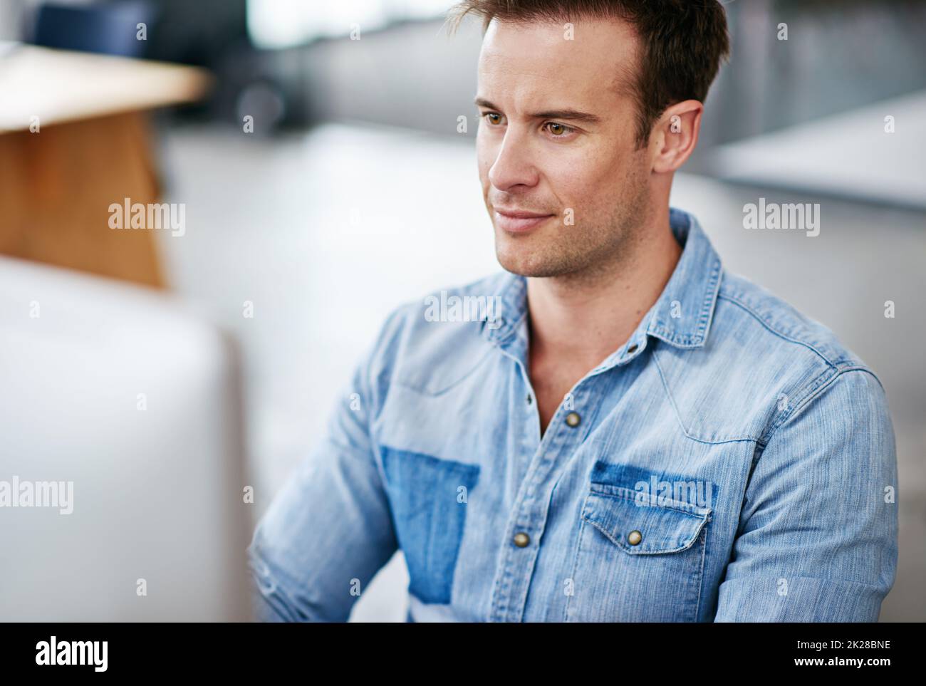 Taking care of business. a handsome young man working at his desk in an ...