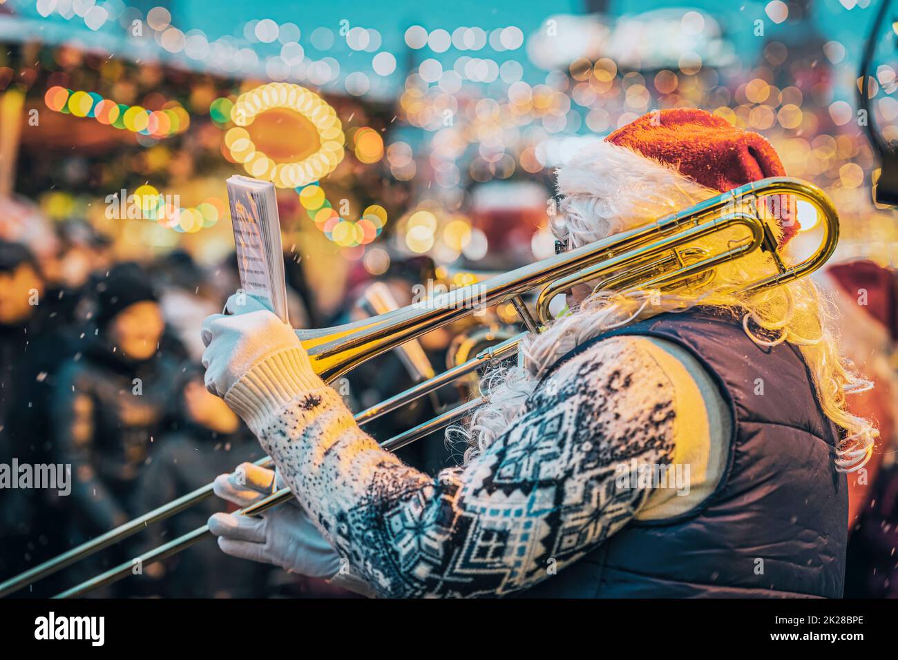 Jazz musician playing trumpet in Santa Claus costume holding notebook ...