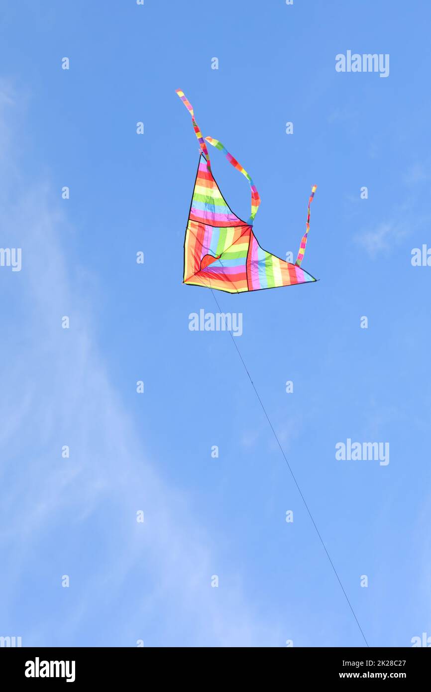 Kite with rainbow colors flying in the blue sky symbol of hope joy ...