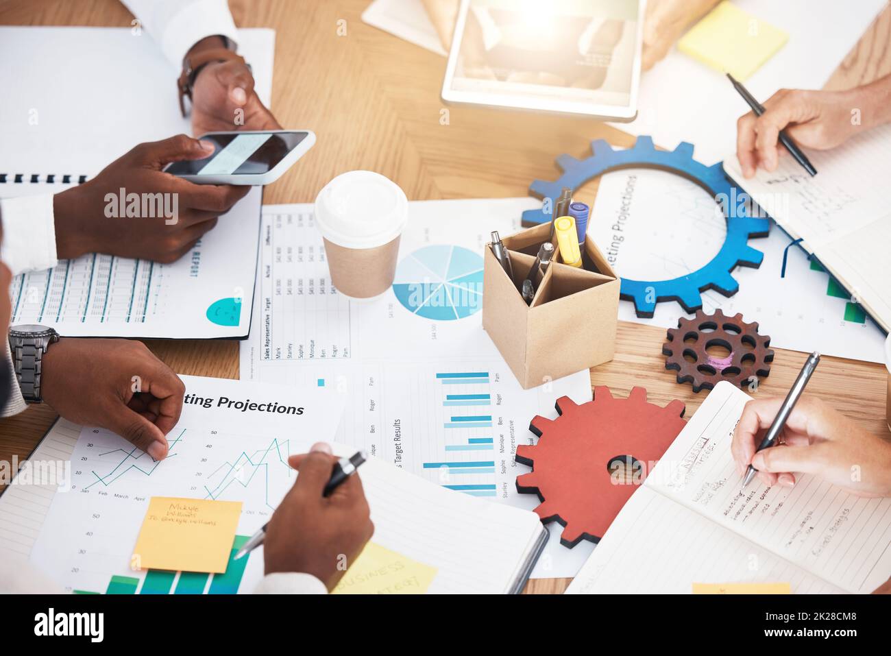 Hands, teamwork and planning with a marketing team working on a table ...