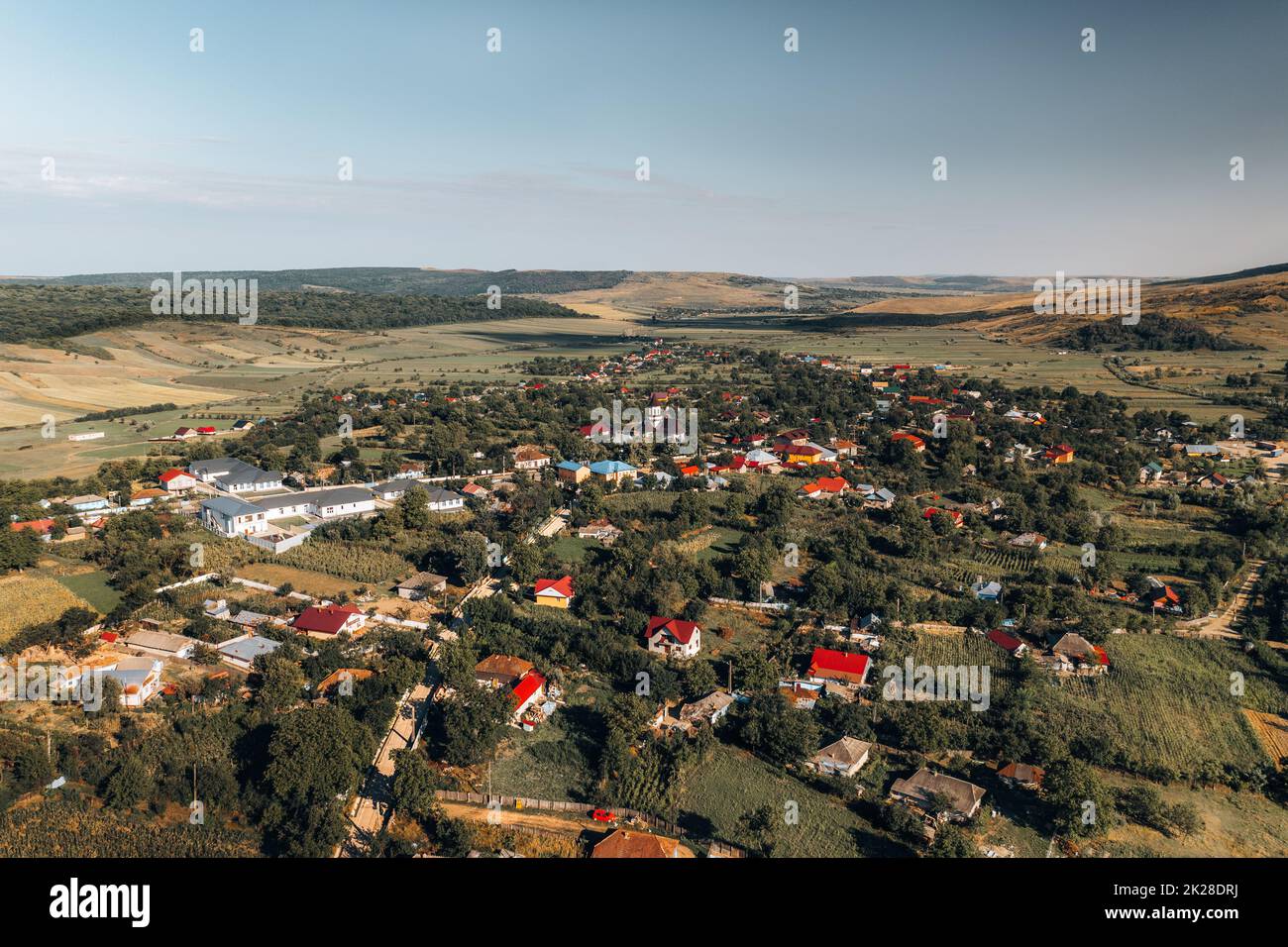 Aerial rural village landscape with yellow patched agriculture fields ...