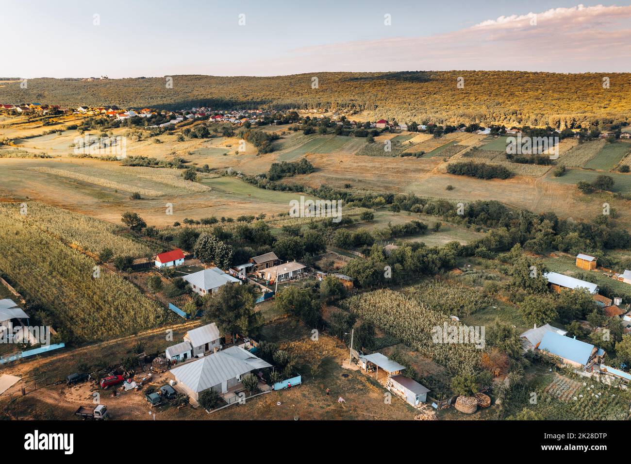 Aerial rural village landscape with yellow patched agriculture fields ...