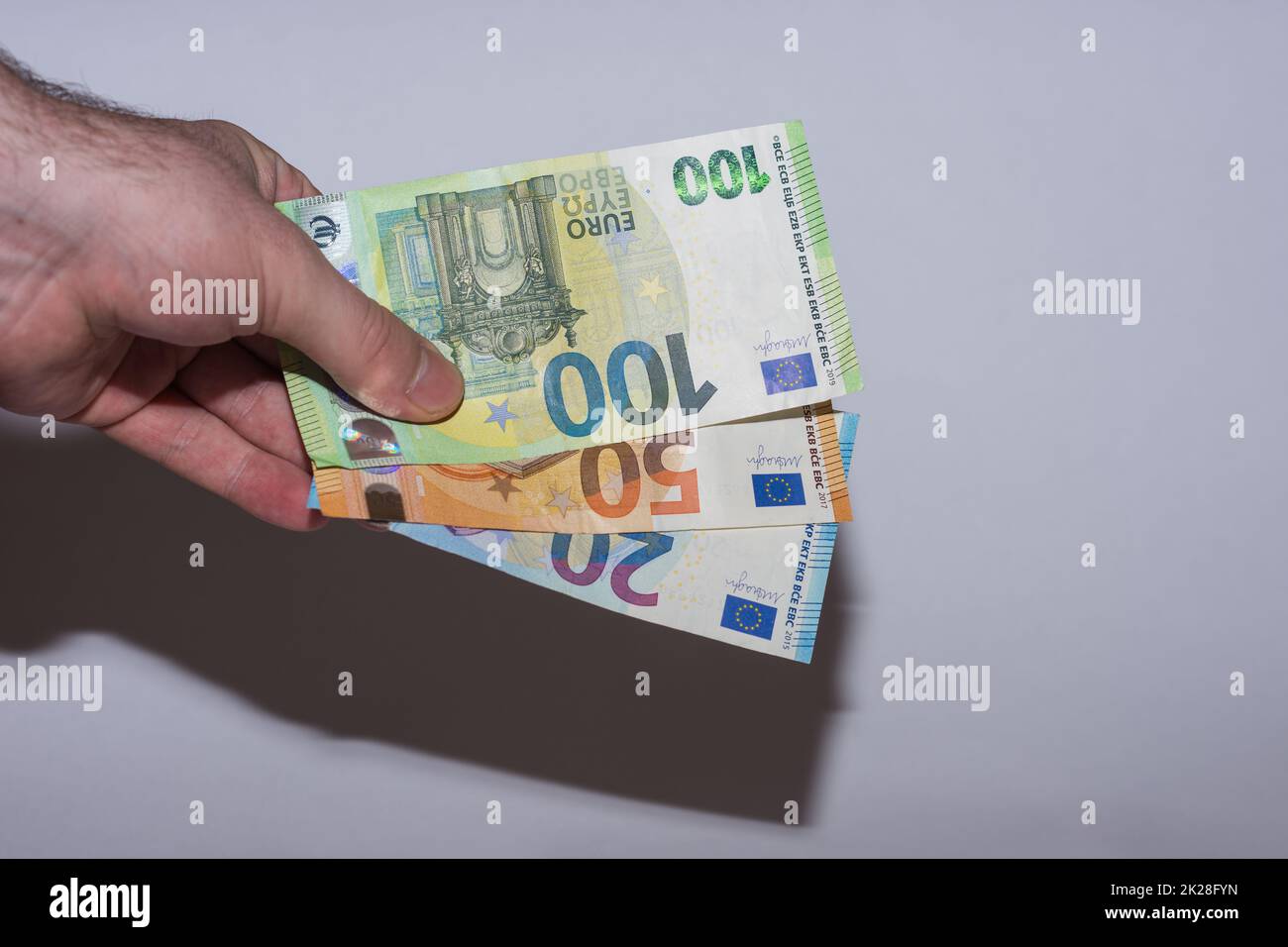 three euro bank notes held in one hand to the bottom with gray Stock ...