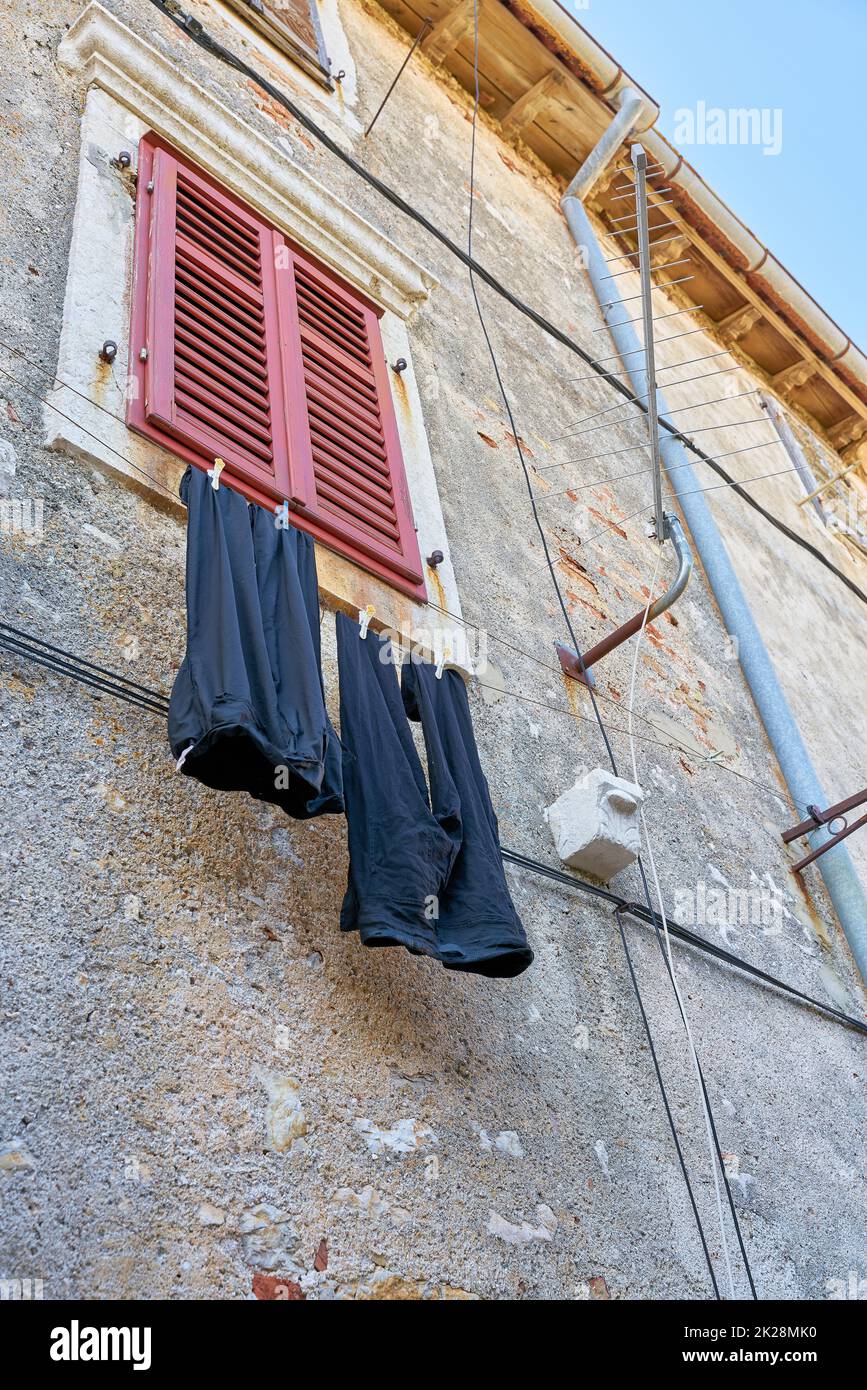 Clothesline with pants on a facade in the old town of Krk in Croatia ...