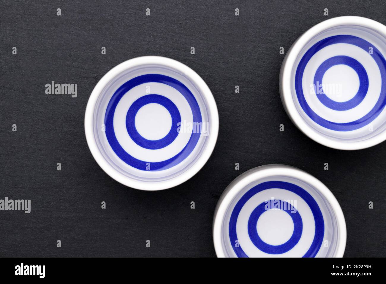 Japanese sake in traditional ceramic ochoko cup on a black background ...