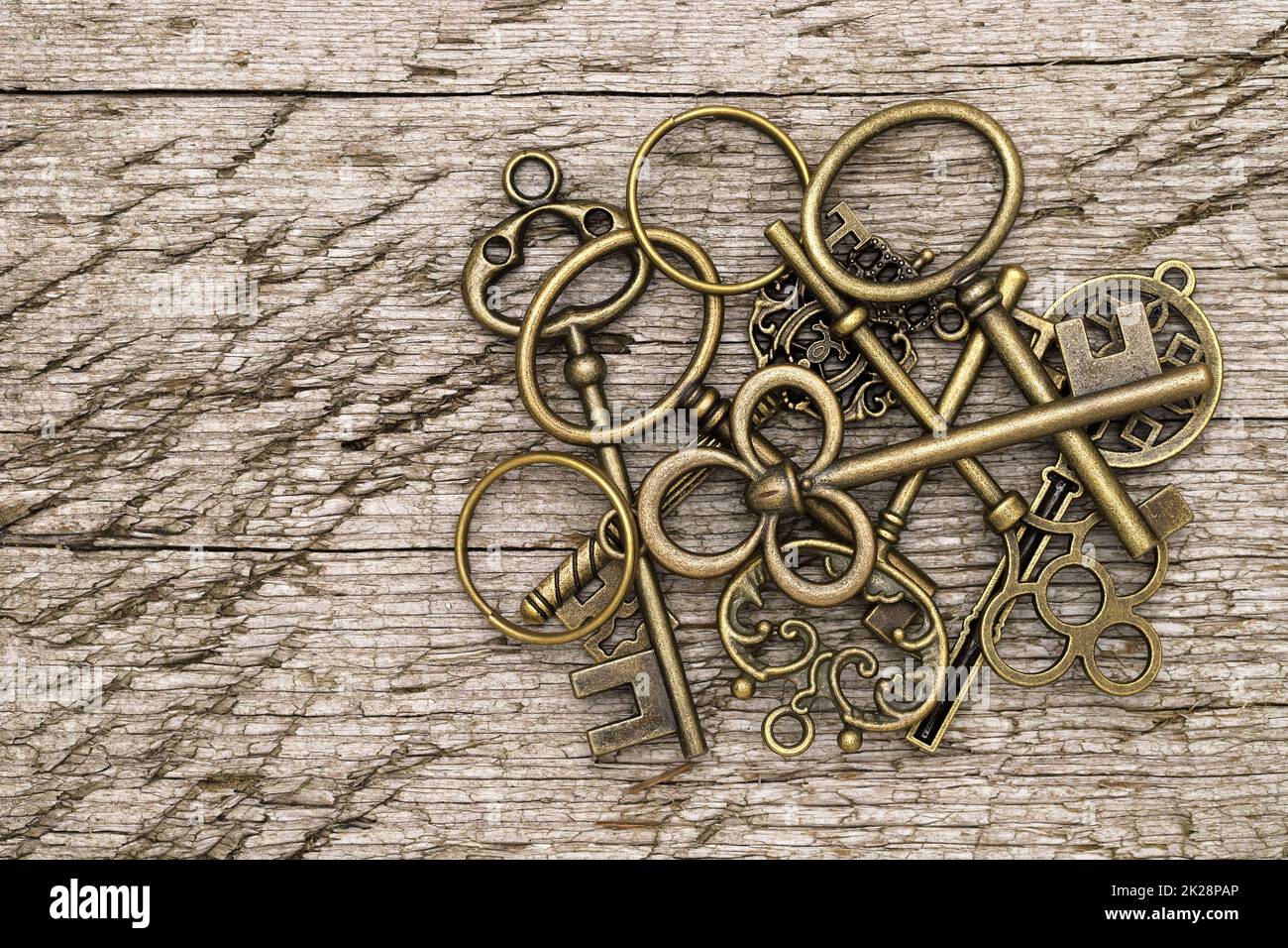 stack of golden vintage key on grungy wooden background Stock Photo - Alamy