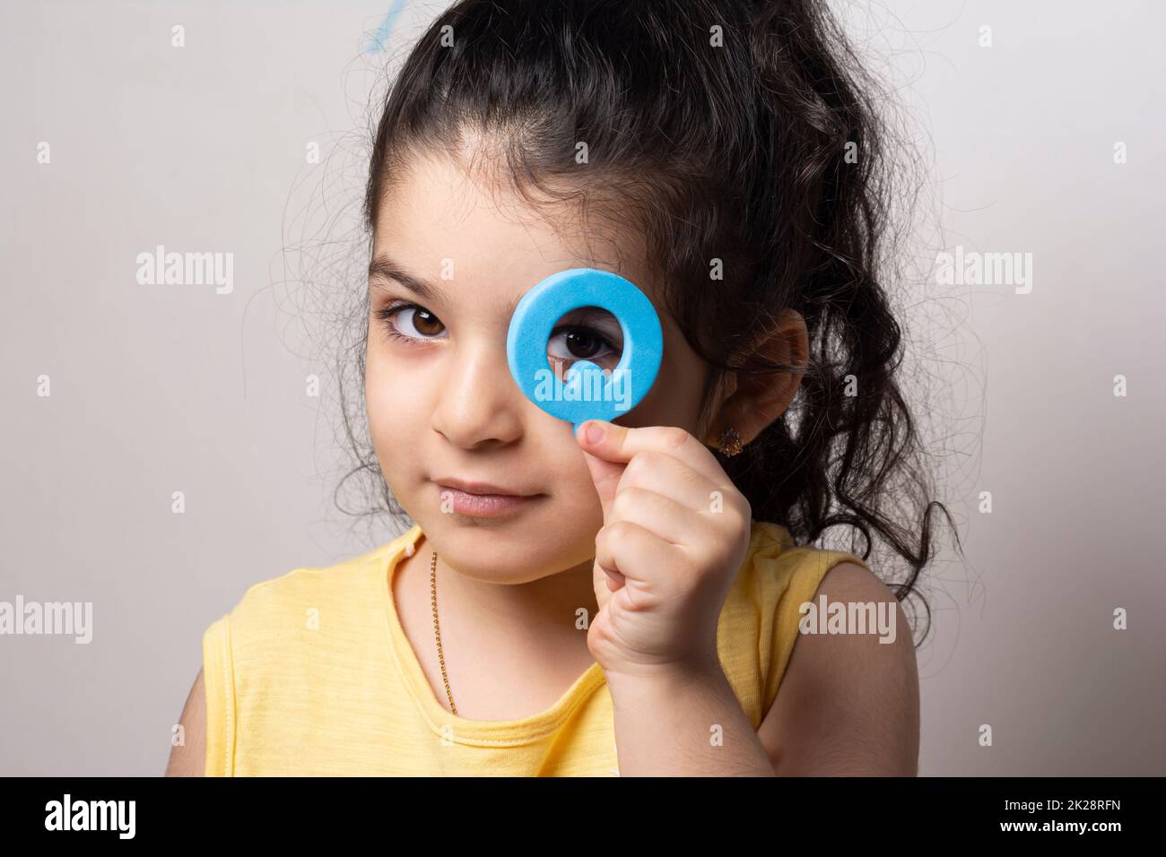 Little girl portrait peeking through English Q letter Stock Photo - Alamy